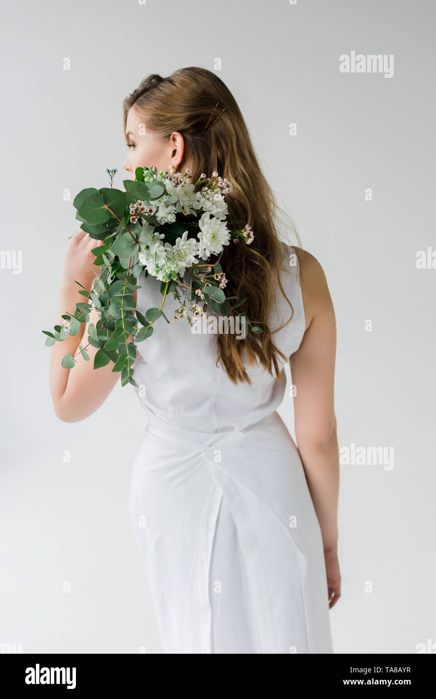 back view of girl in dress holding flowers behind back isolated on ...