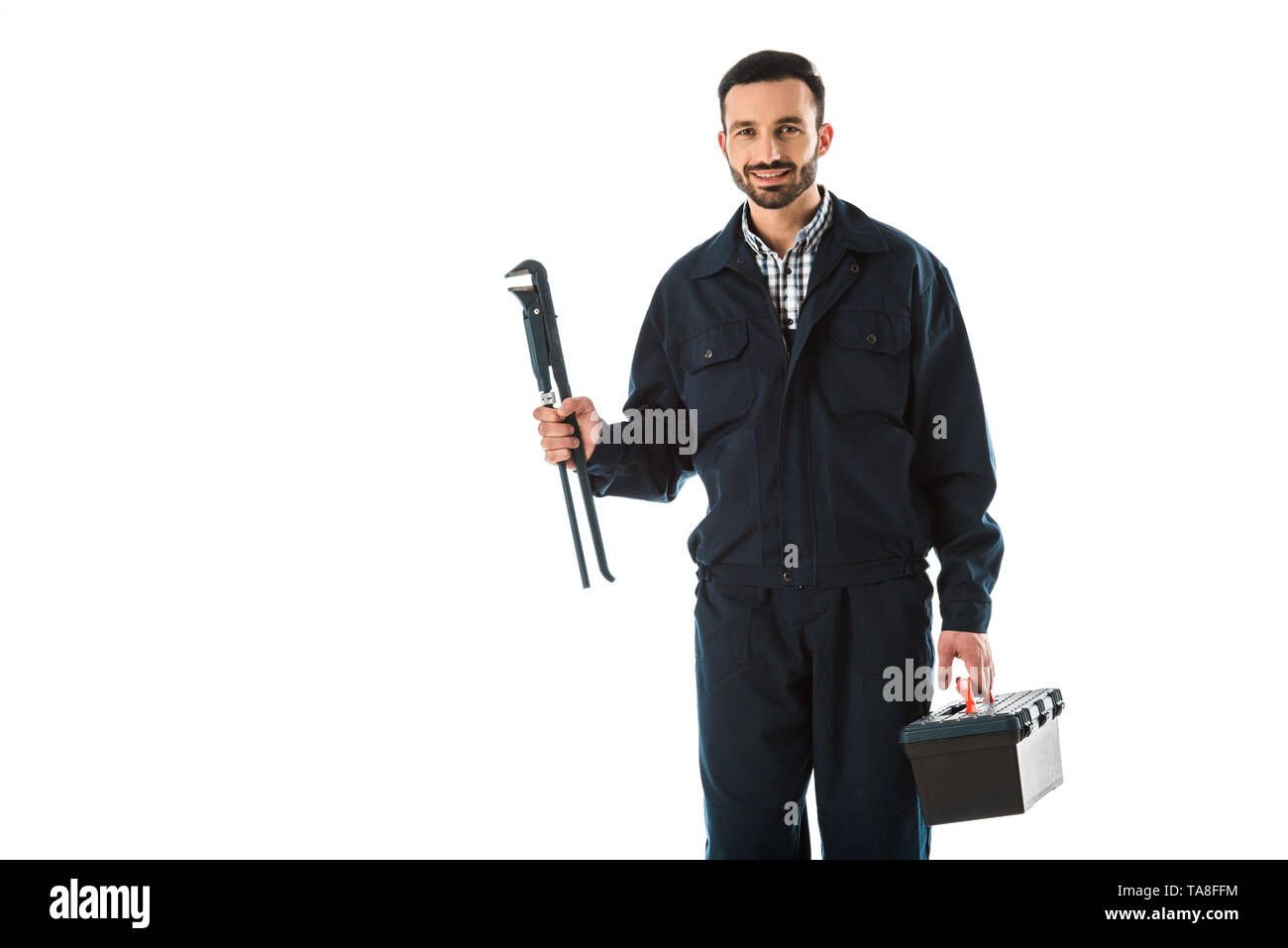 cheerful plumber in overalls holding adjustable wrench and toolbox ...