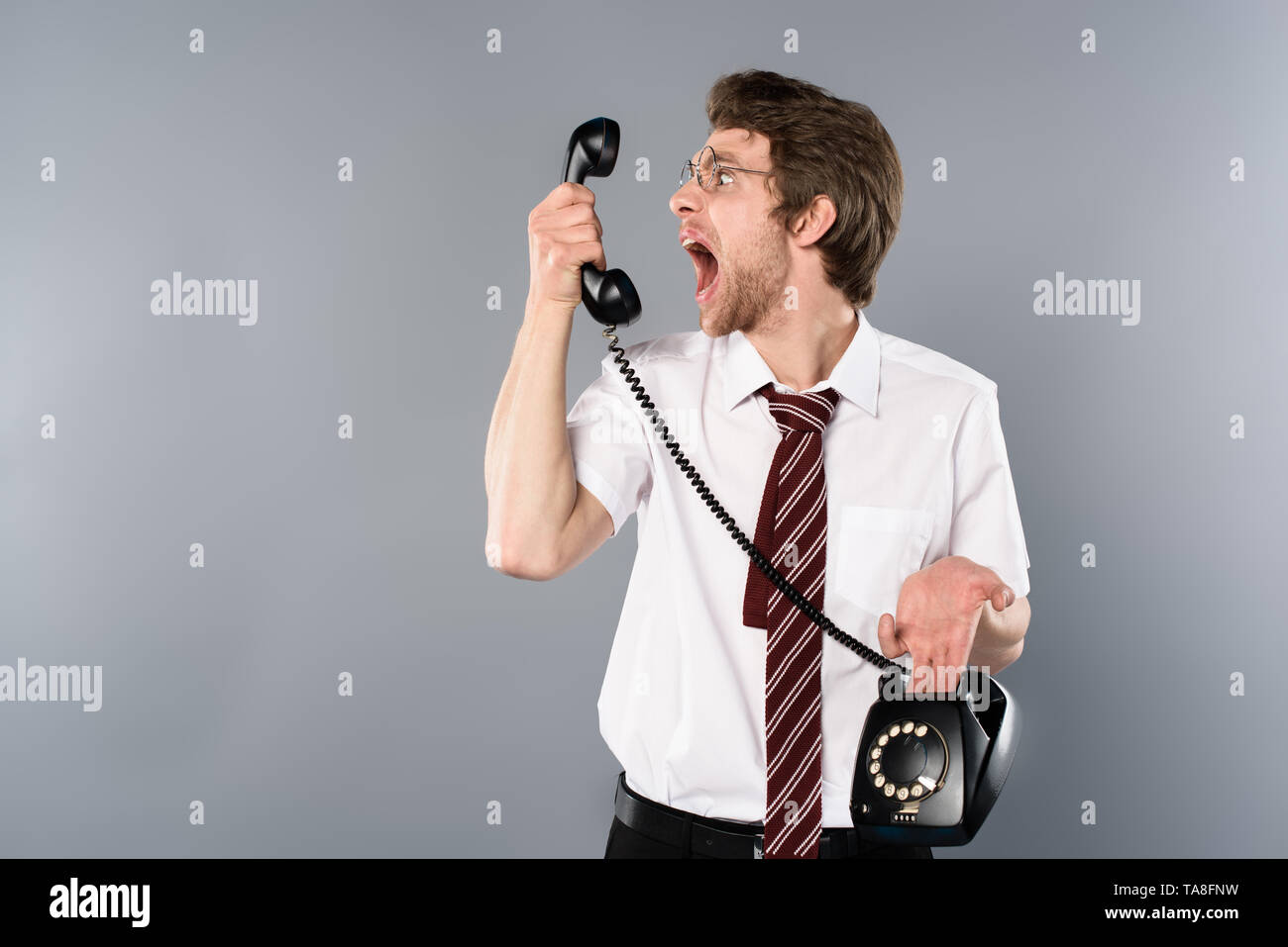 angry businessman in glasses yelling in vintage phone Stock Photo - Alamy