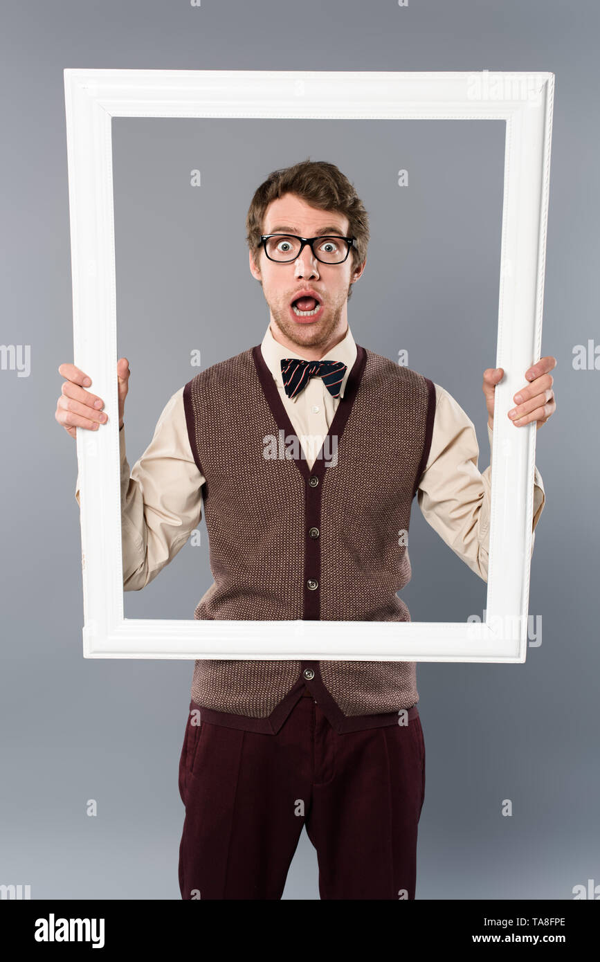 shocked man holding white frame on grey background Stock Photo - Alamy