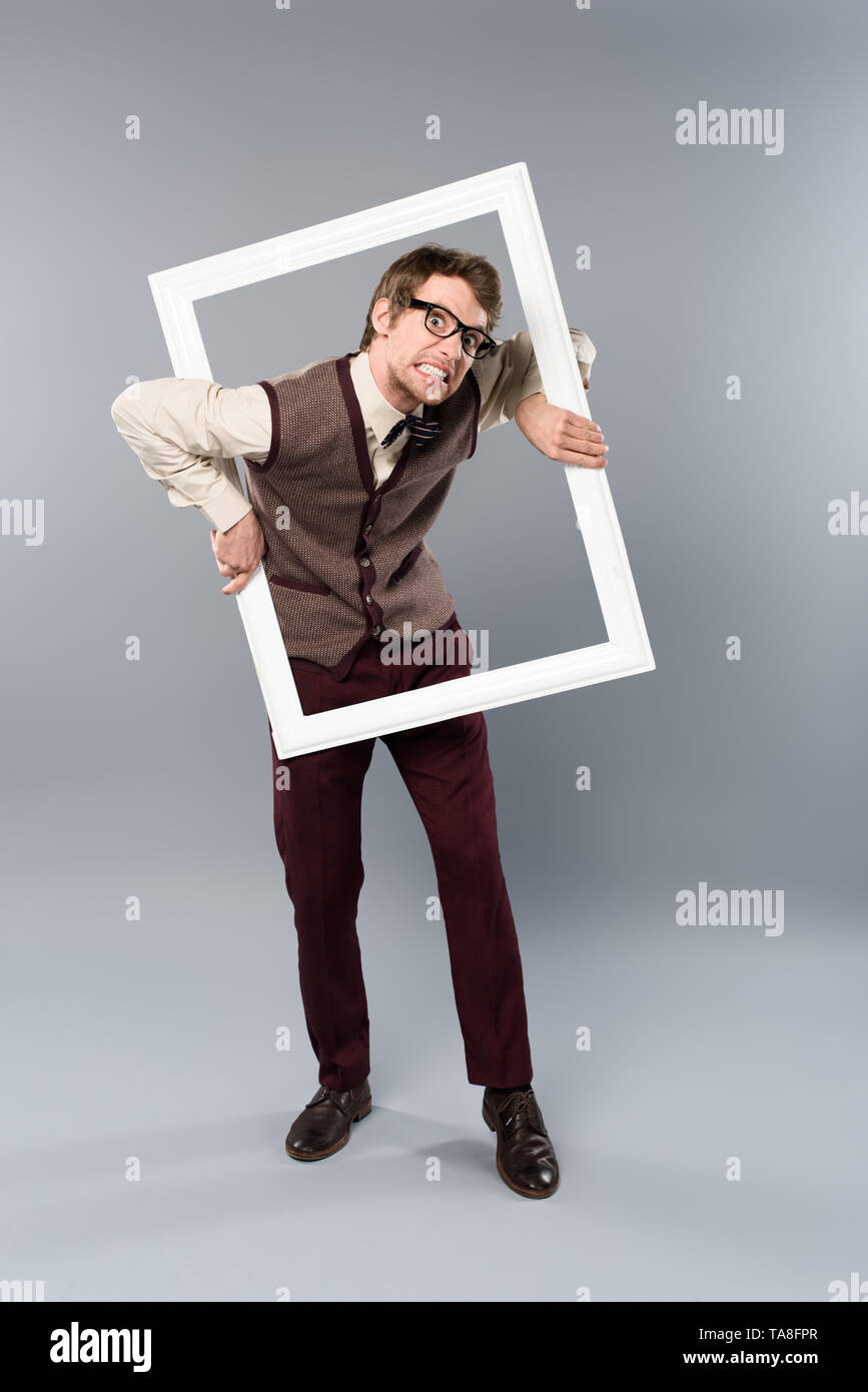 angry man holding white frame on grey background Stock Photo - Alamy