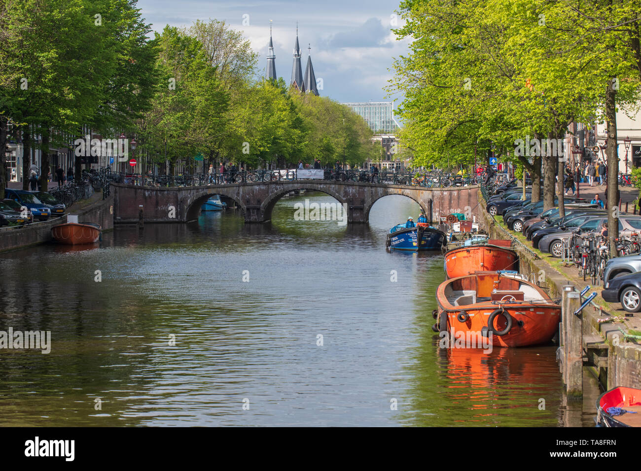 Amsterdam canal boats and a canal bridge - spring day in Amsterdam with ...