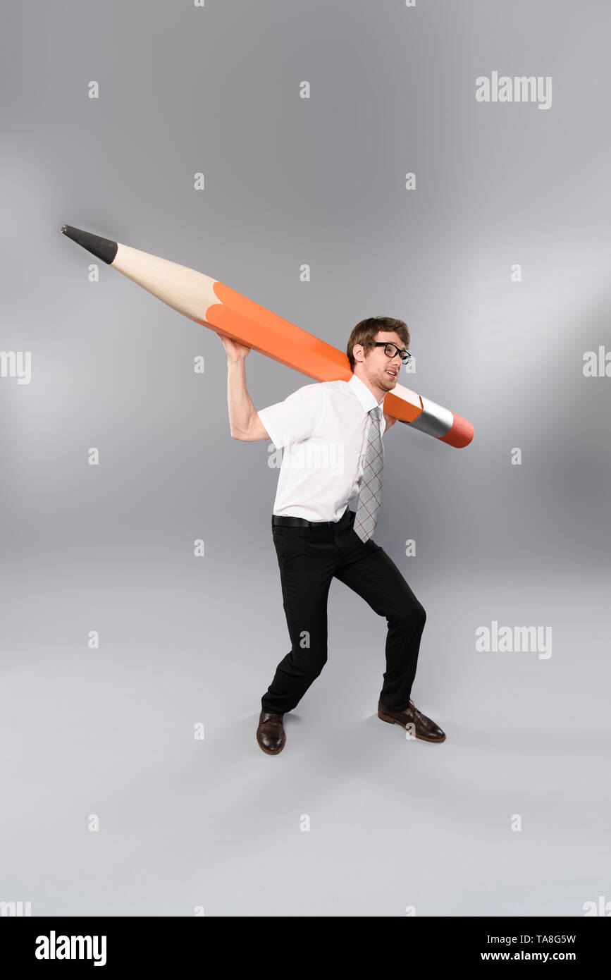 funny tense businessman in glasses holding huge and heavy decorative ...