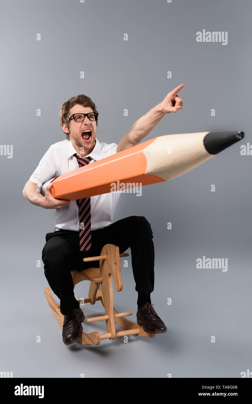 funny businessman in glasses holding huge decorative pencil,pointing ...