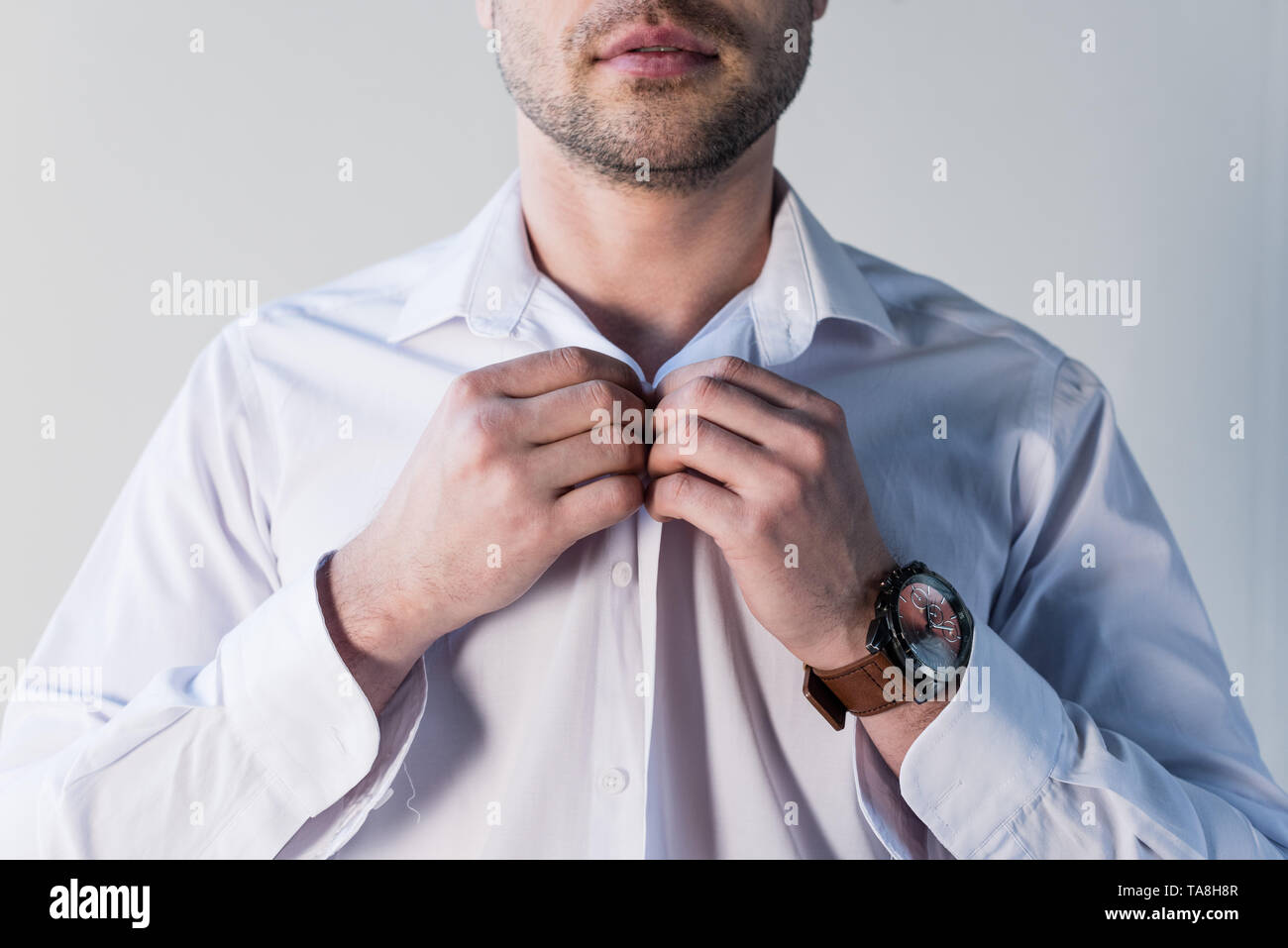 partial view of confident handsome man putting on white shirt Stock ...