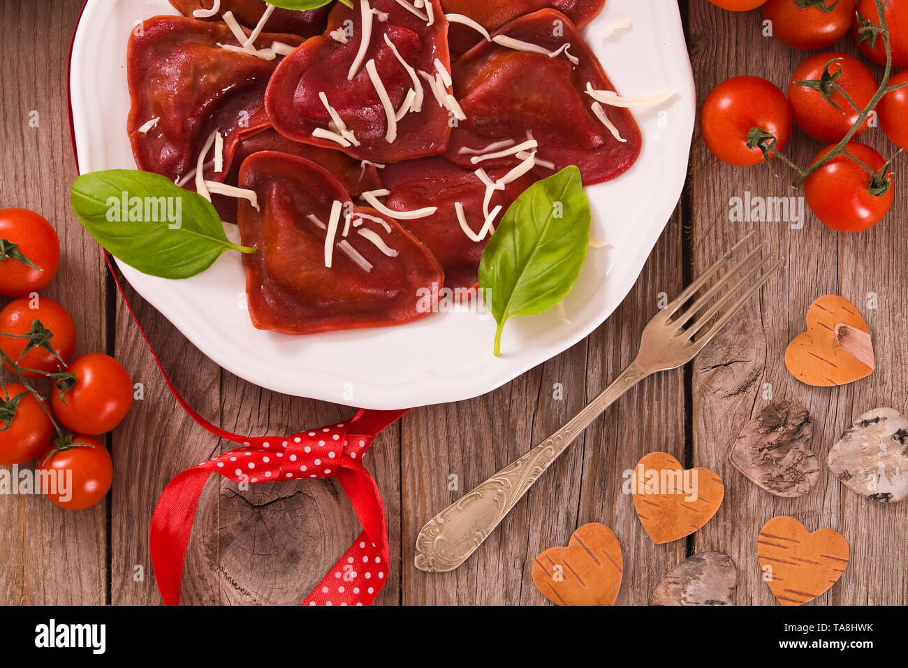 Red heart ravioli with tomato, mozzarella and basil Stock Photo - Alamy