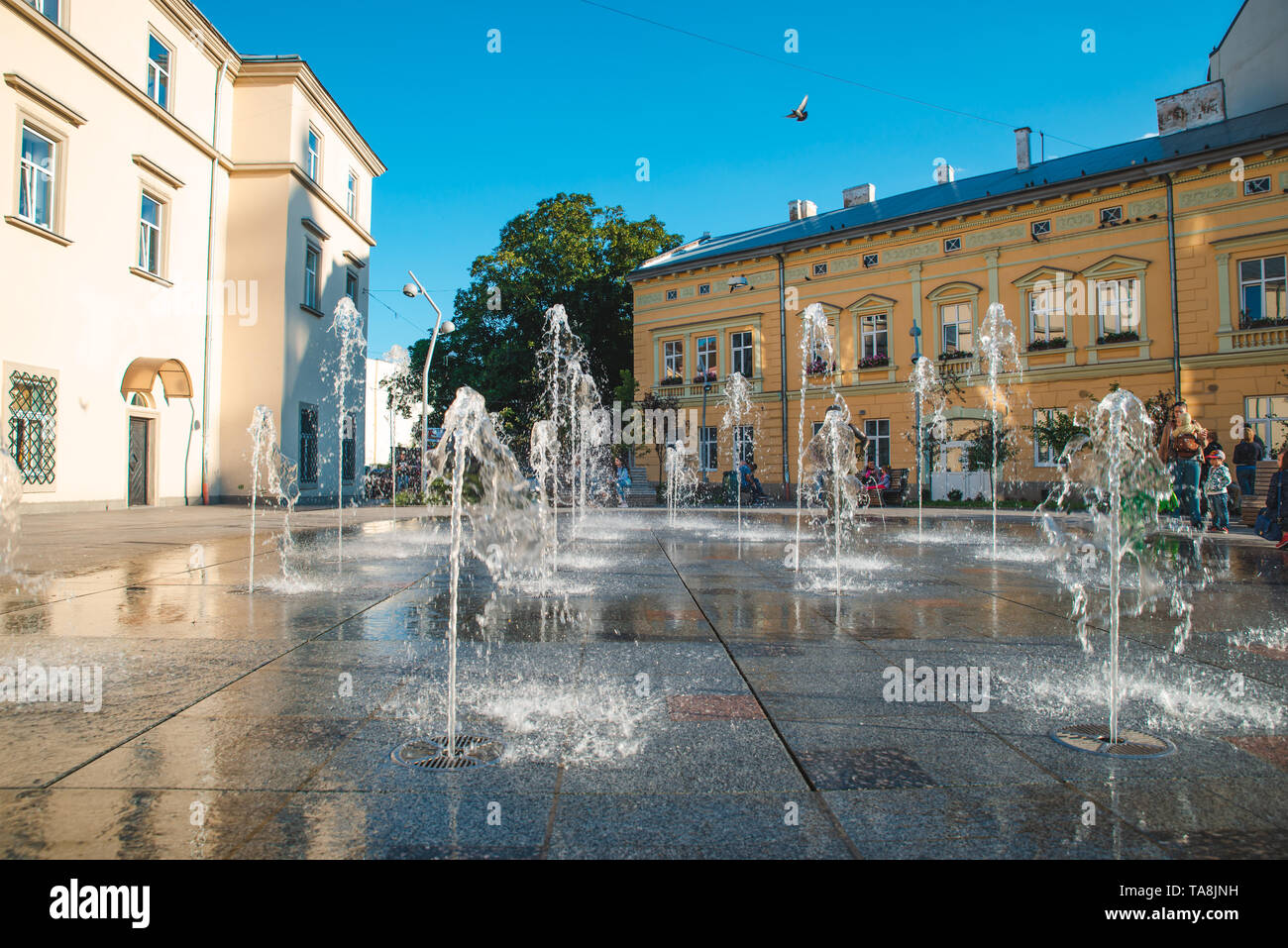 kids playing at city square near fountain. summer time Stock Photo - Alamy