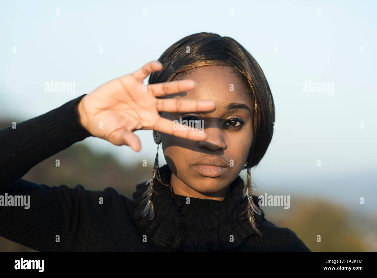 Woman with african appearance against sunlight, light background ...