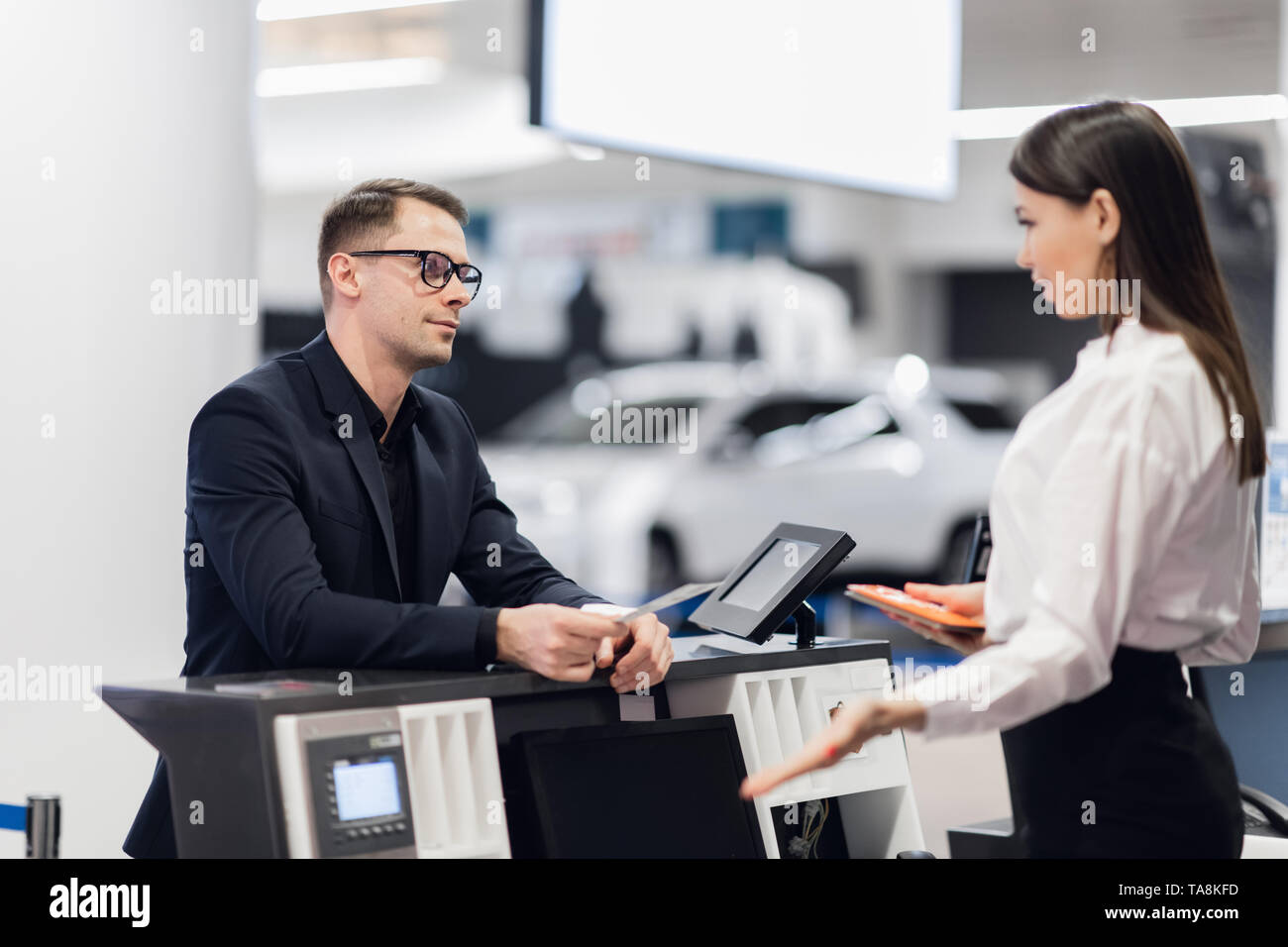 Staff At Airport Check In Desk Handing Ticket To Businessman Stock ...