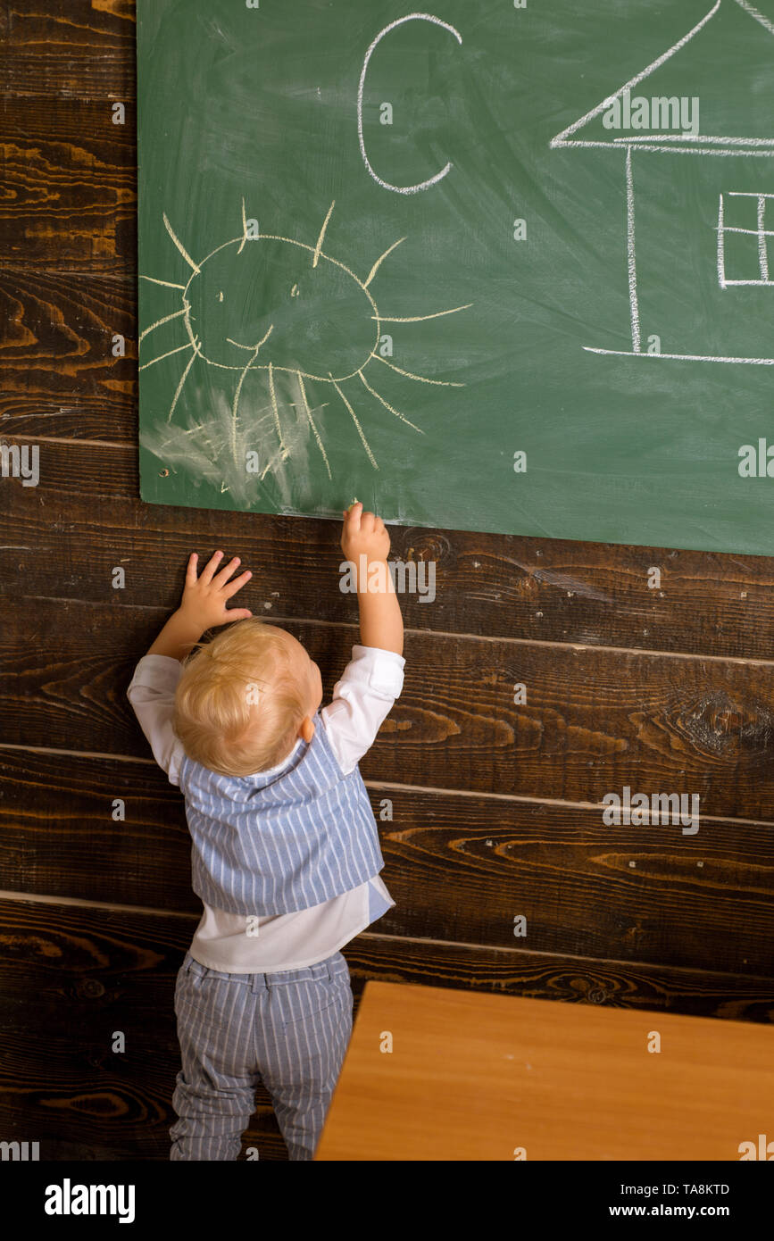 Little boy learn drawing on classroom chalkboard. Child have lesson in ...