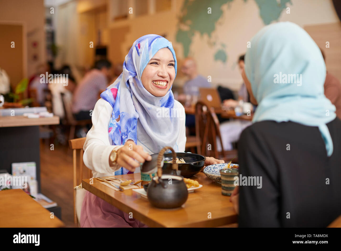 Young South-east Asian women eating at restaurant Stock Photo - Alamy