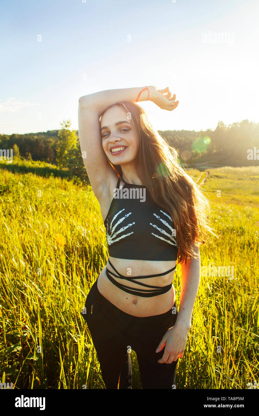 young pretty girl posing cheerful in green grass outside, enjoing ...