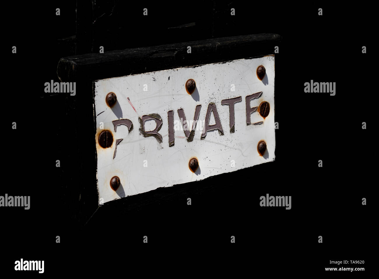 Dilapidated private sign with rusty screw head fixings and peeling ...
