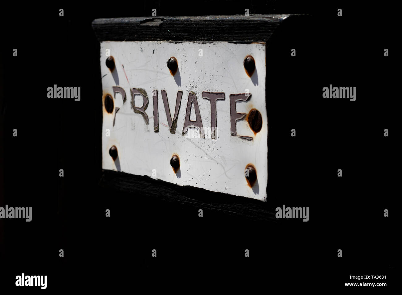 Dilapidated private sign with rusty screw head fixings and peeling ...