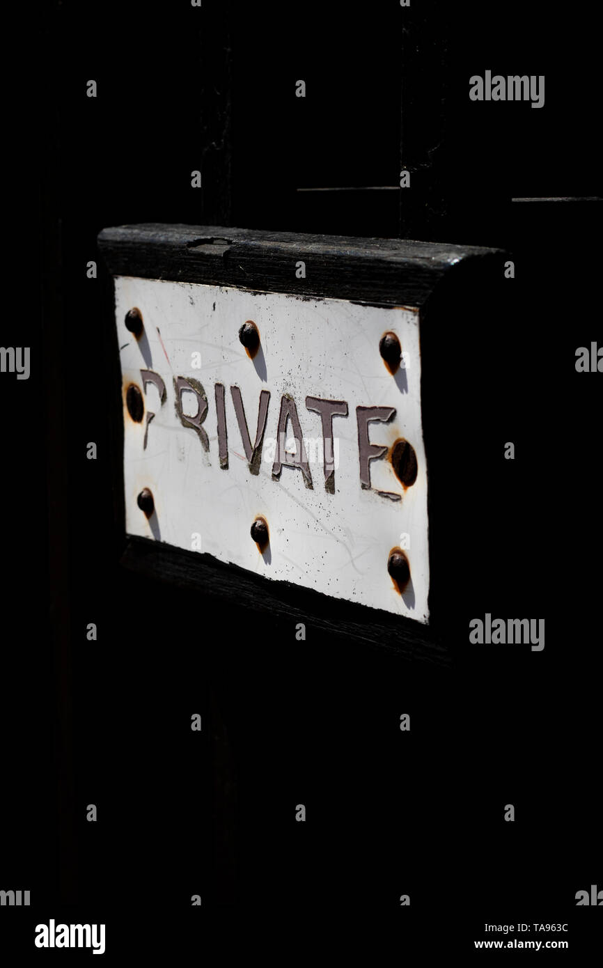 Dilapidated private sign with rusty screw head fixings and peeling ...