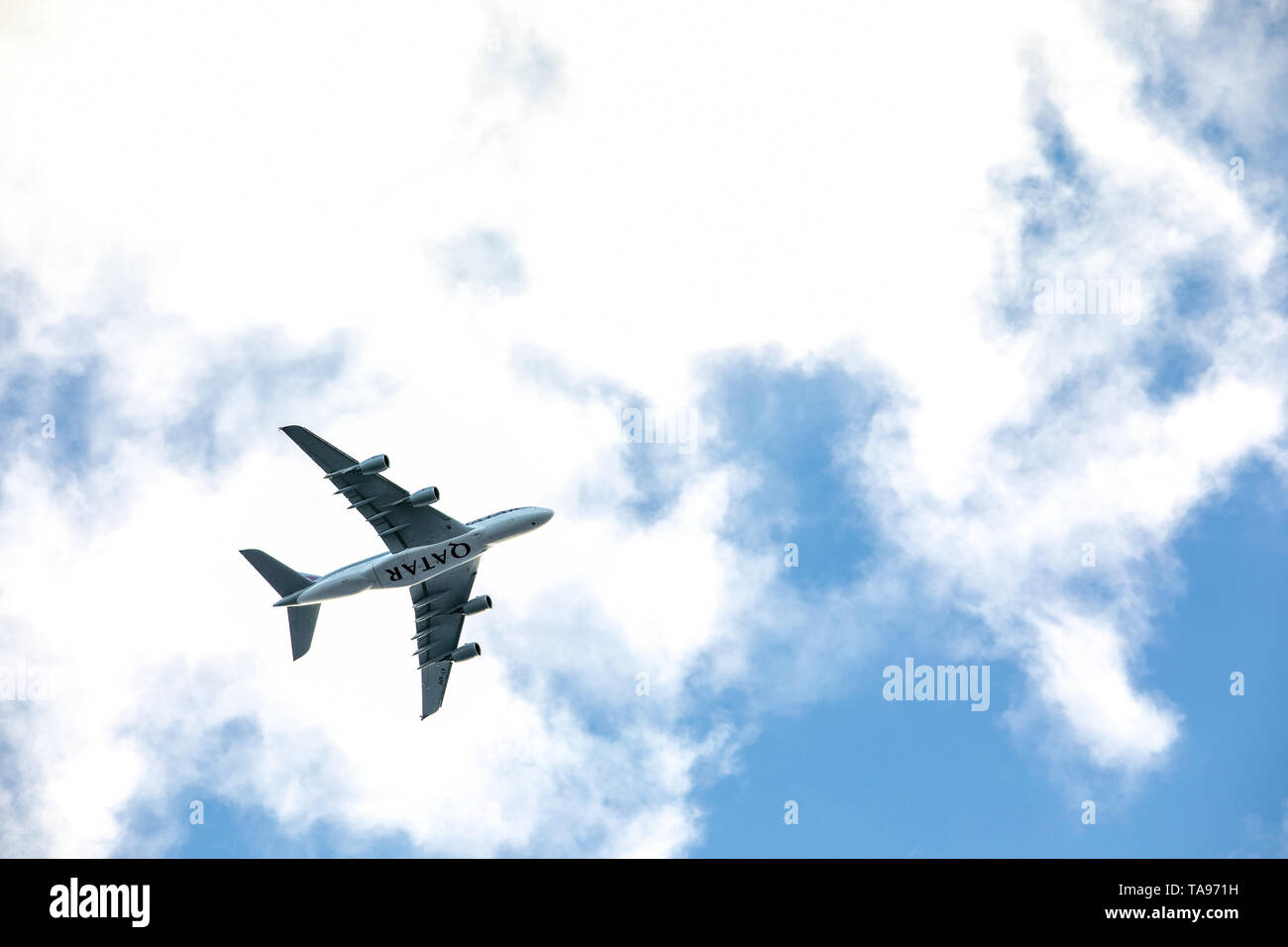 Qatar Airbus airplane flies over the city, blue and cloudy sky. Qatar ...