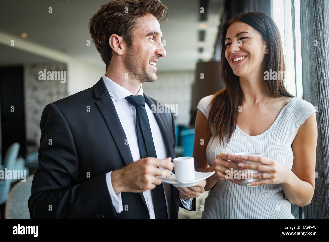 Beautiful young couple talking to each other and smiling while enjoying ...