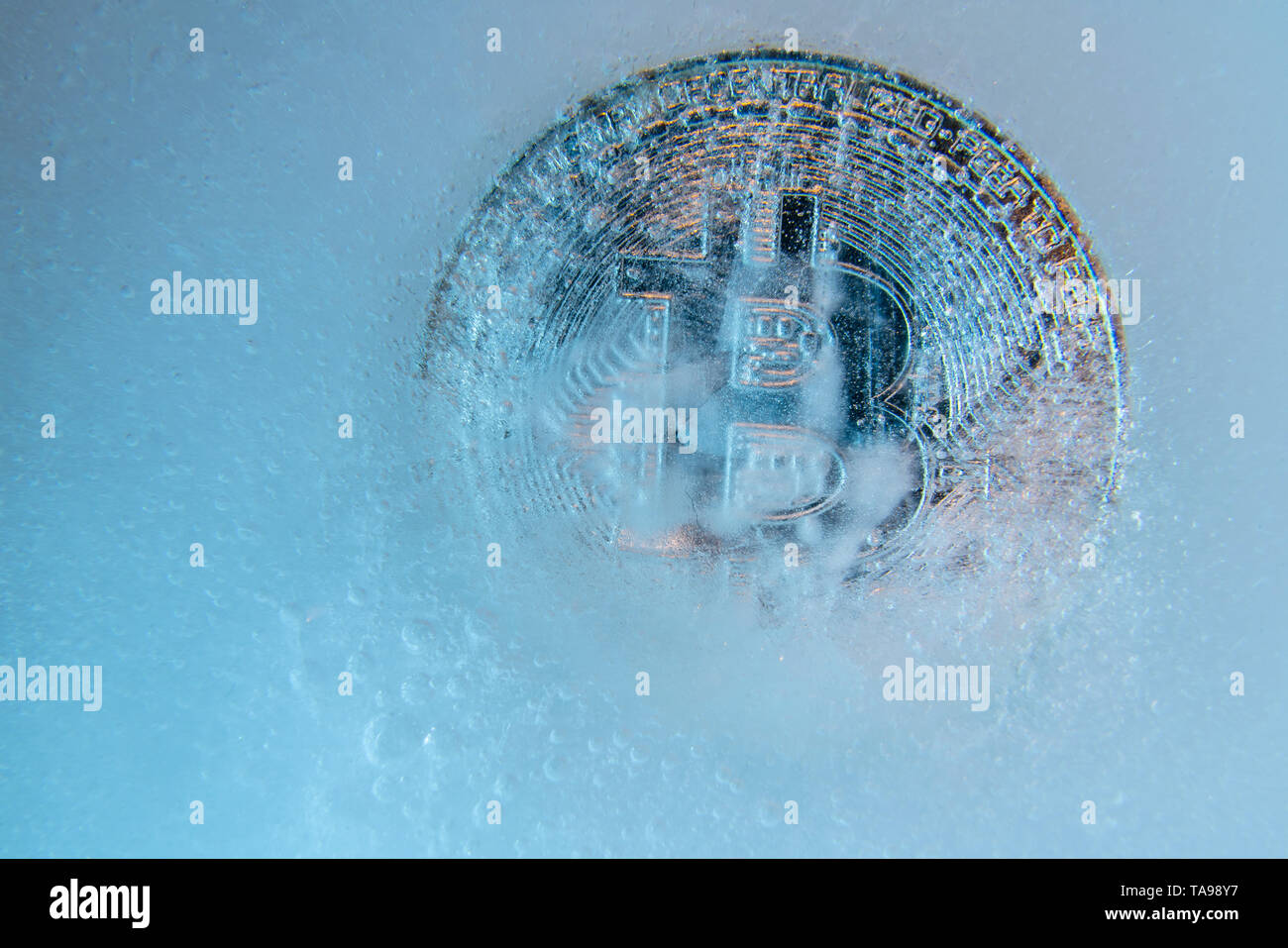Silver Bitcoin, bit coin online digital currency frozen in the blue ice ...