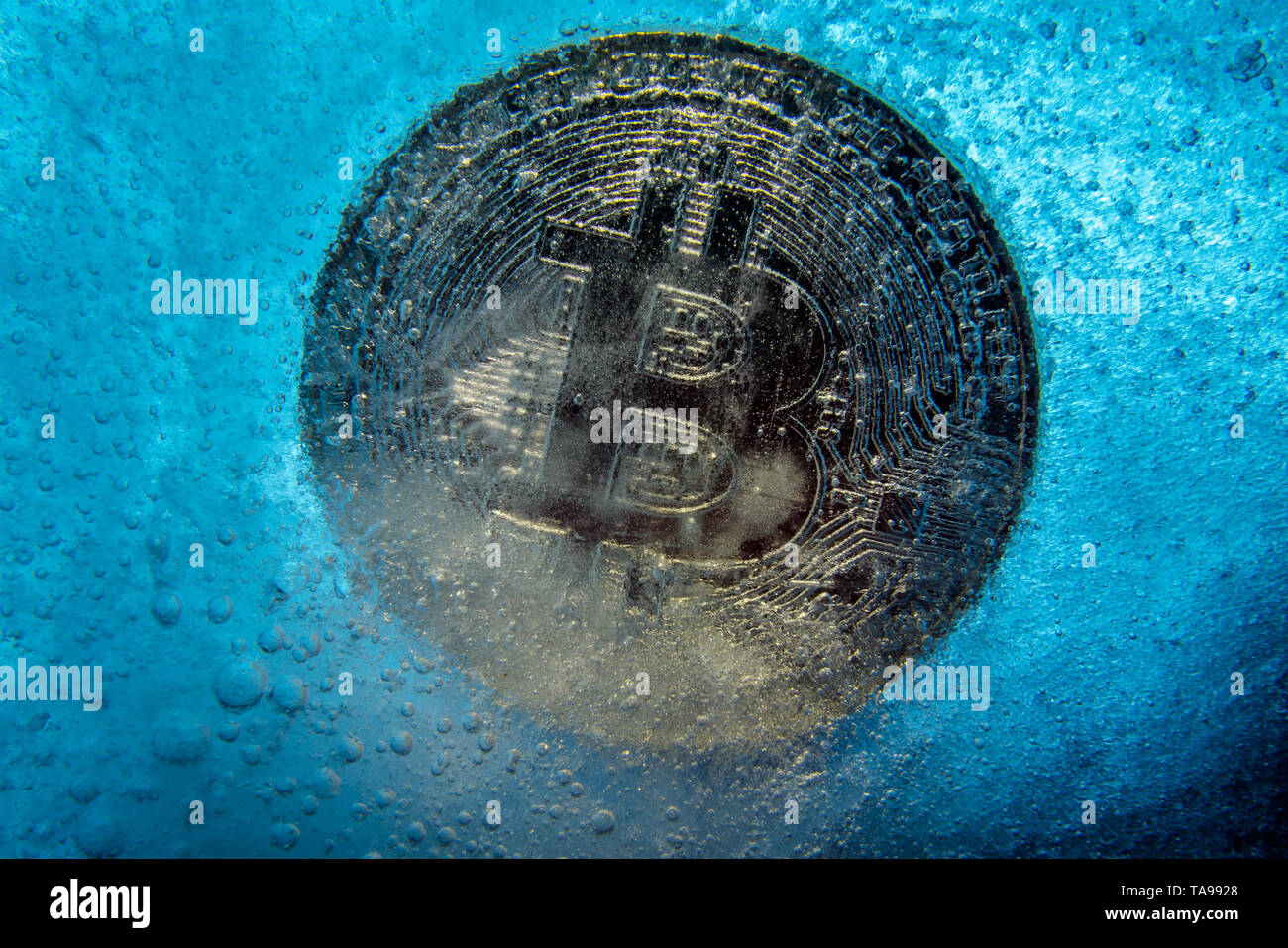Silver Bitcoin, bit coin online digital currency frozen in the blue ice ...