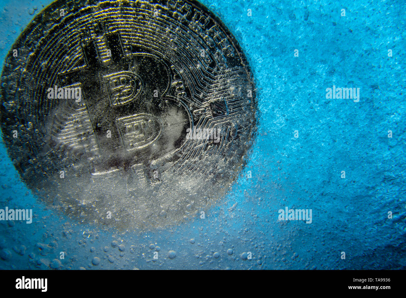 Silver Bitcoin, bit coin online digital currency frozen in the blue ice ...