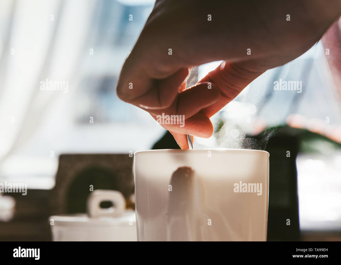 Woman mixing tea in white cup with multiple steam particles Stock Photo ...