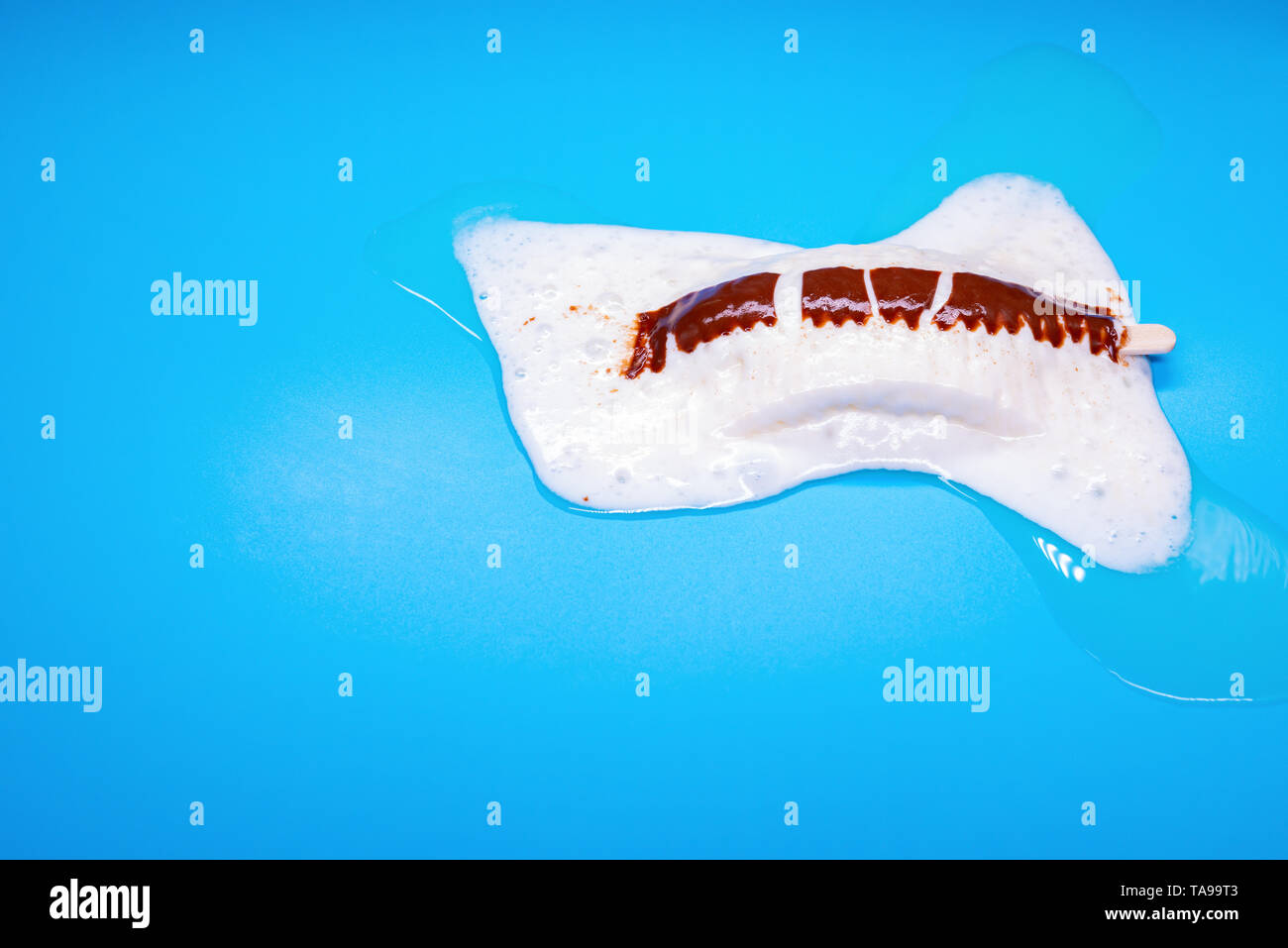 side view half melted chocolate flavor popsicle on blue background ...