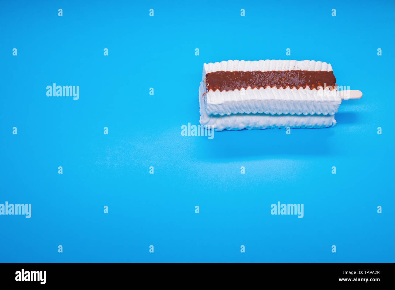 white color popsicle on a blue background Stock Photo - Alamy