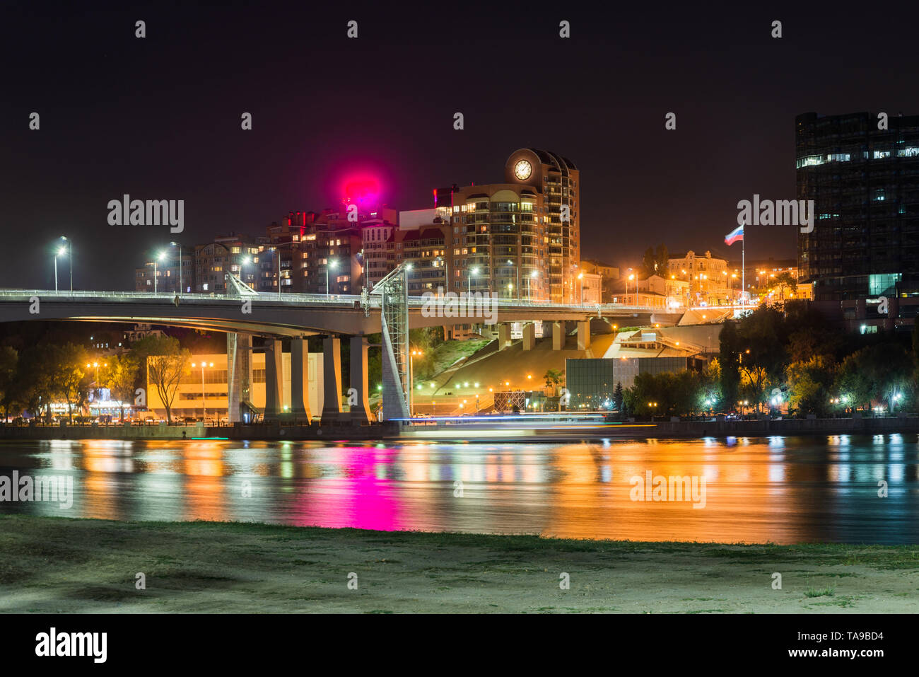 Sandy beach and bridge over the river and night city on the background ...