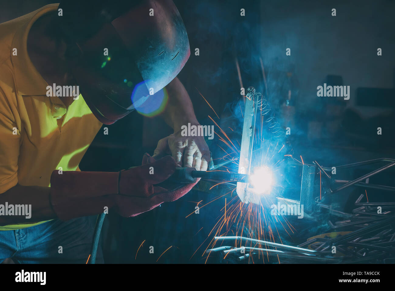 Industrial Worker at the factory or workshop welding steel elements ...
