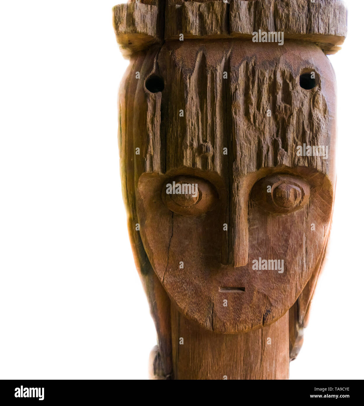 the face of a African carved wooden statue in closeup, isolated on a ...