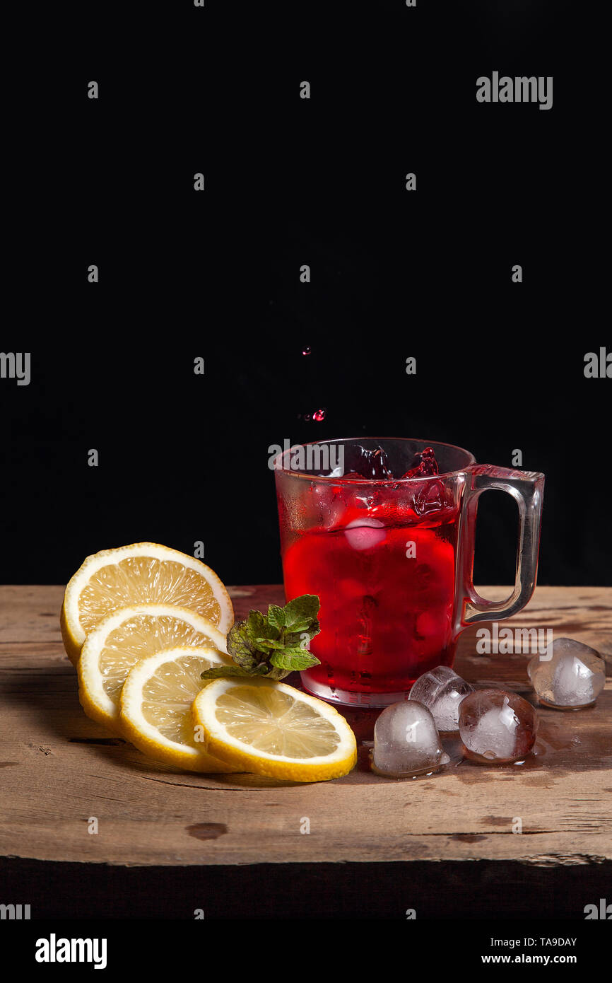 Summer iced drink - hibiscus cold tea with ice, lemon and mint. Big ...