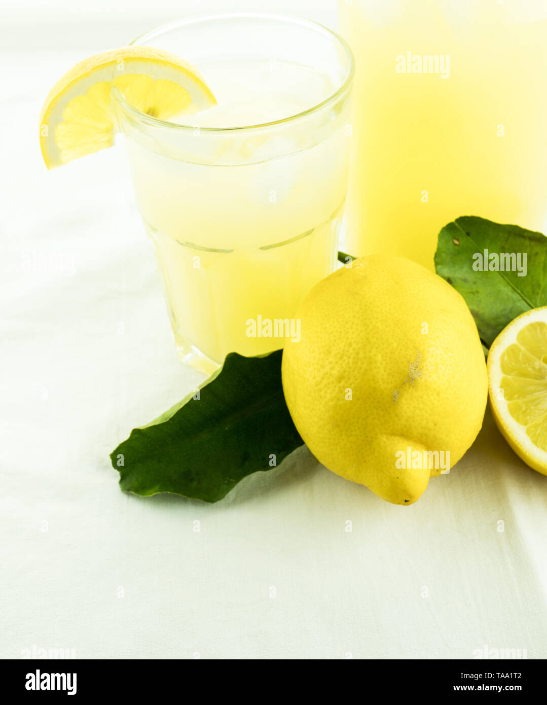 fresh organic lemonade in a jar with lemons and leaves and a glass of ...