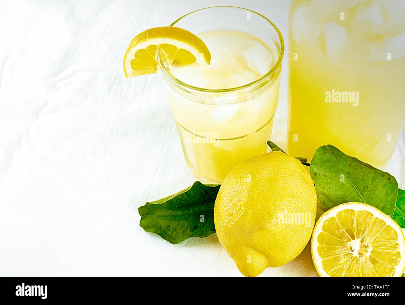 fresh organic lemonade in a jar with lemons and leaves and a glass of ...