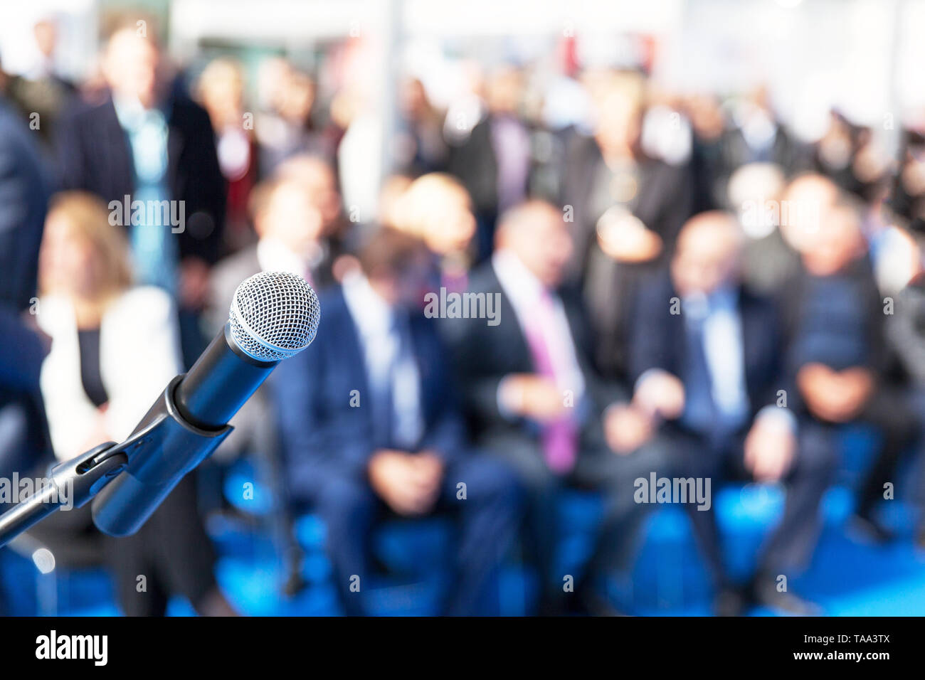 Microphone in focus against blurred audience Stock Photo - Alamy