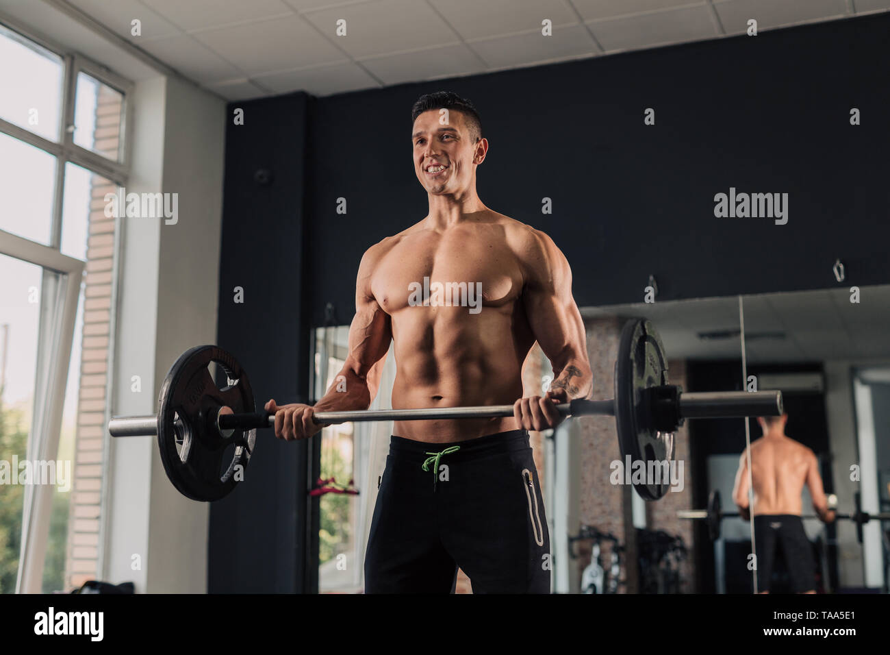 Young muscular man in the gym doing exercise Stock Photo - Alamy