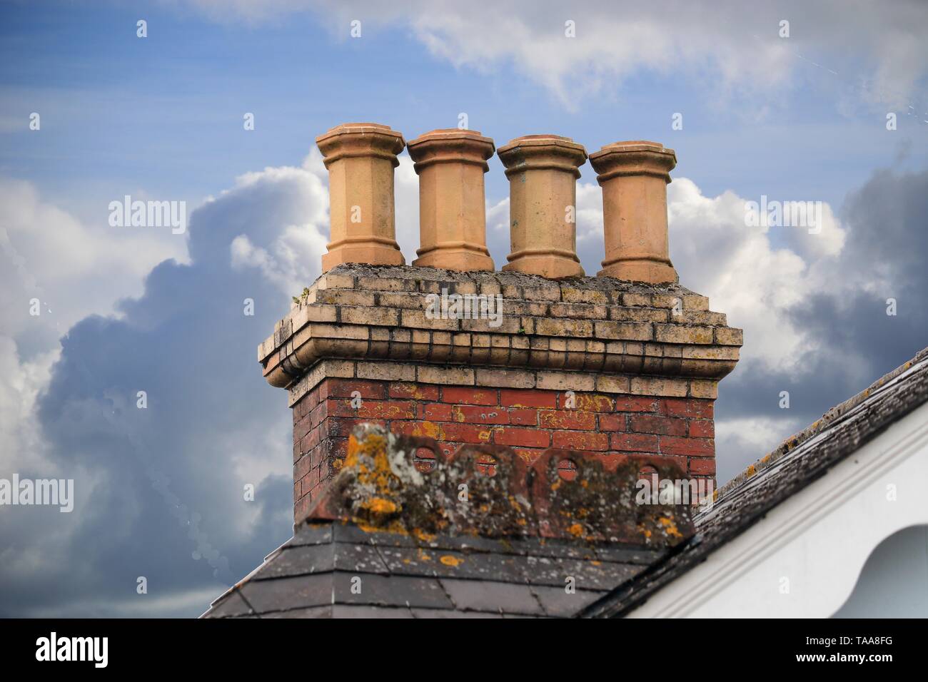 Chimneys on an old roof in Ivybridge, Devon, England, a typical row of ...