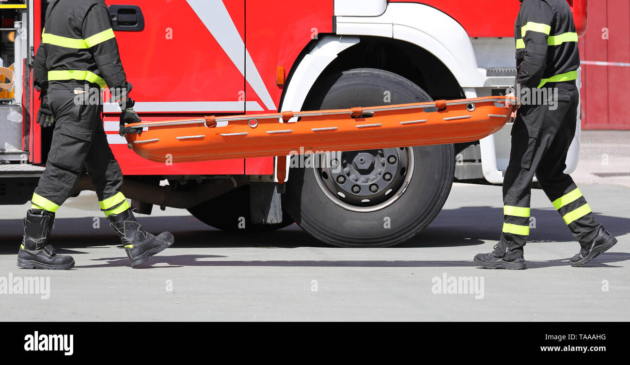 two firefighters with stretcher and the fire engine in background Stock ...
