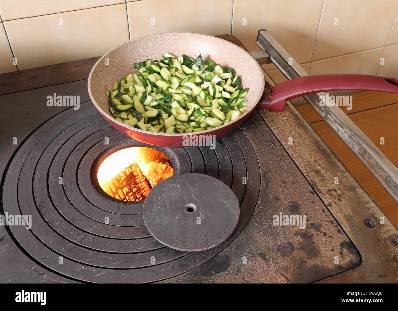 zucchini in a pan are cooked over a wood-burning stove in a mountain ...