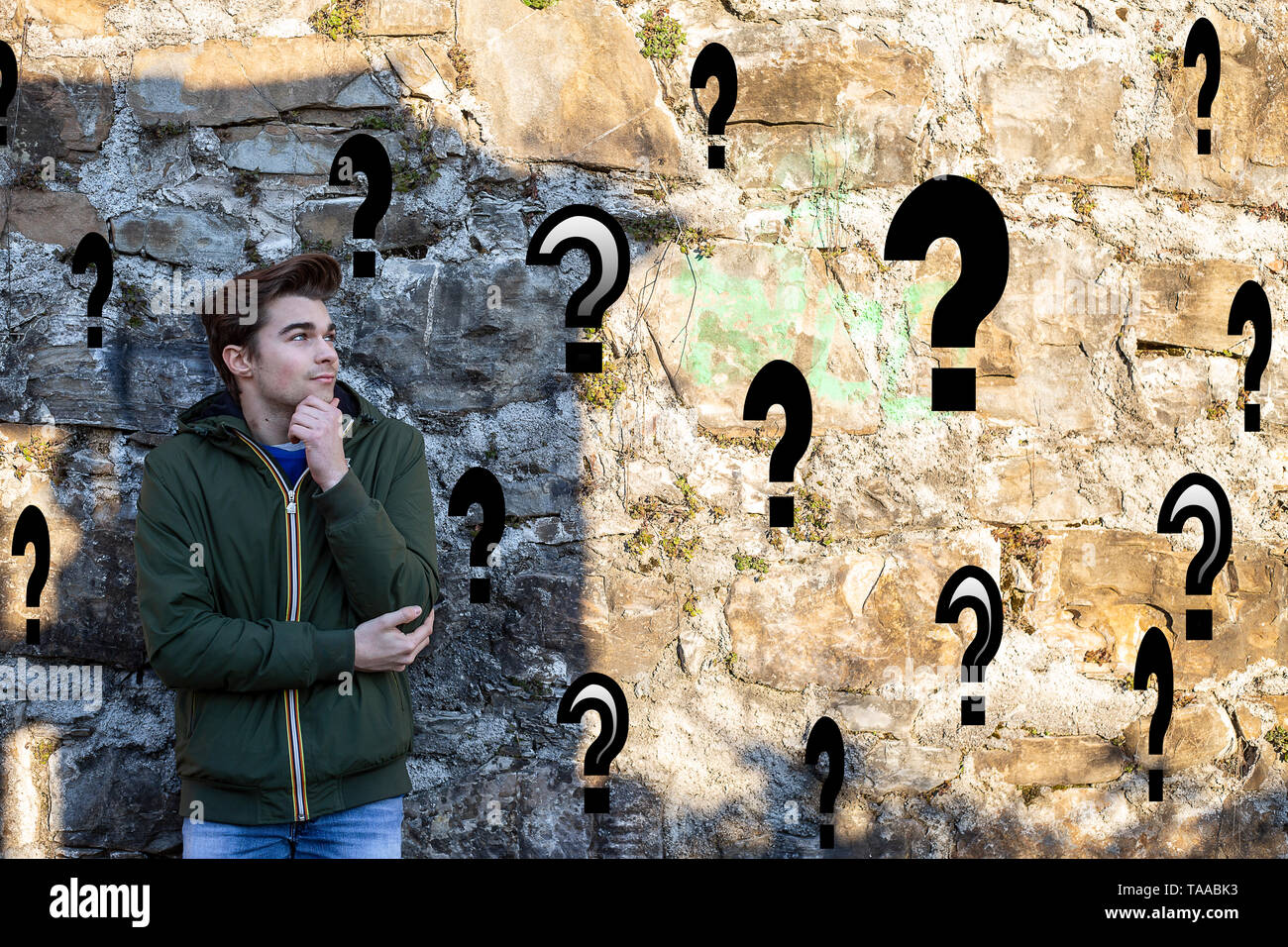 Young man with thoughtful expression and question marks over his head ...