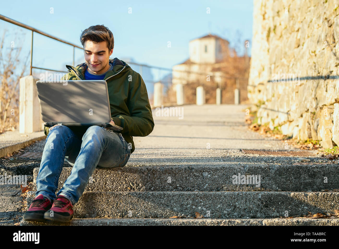 Having opportunity to work everywhere. Handsome young man working on ...