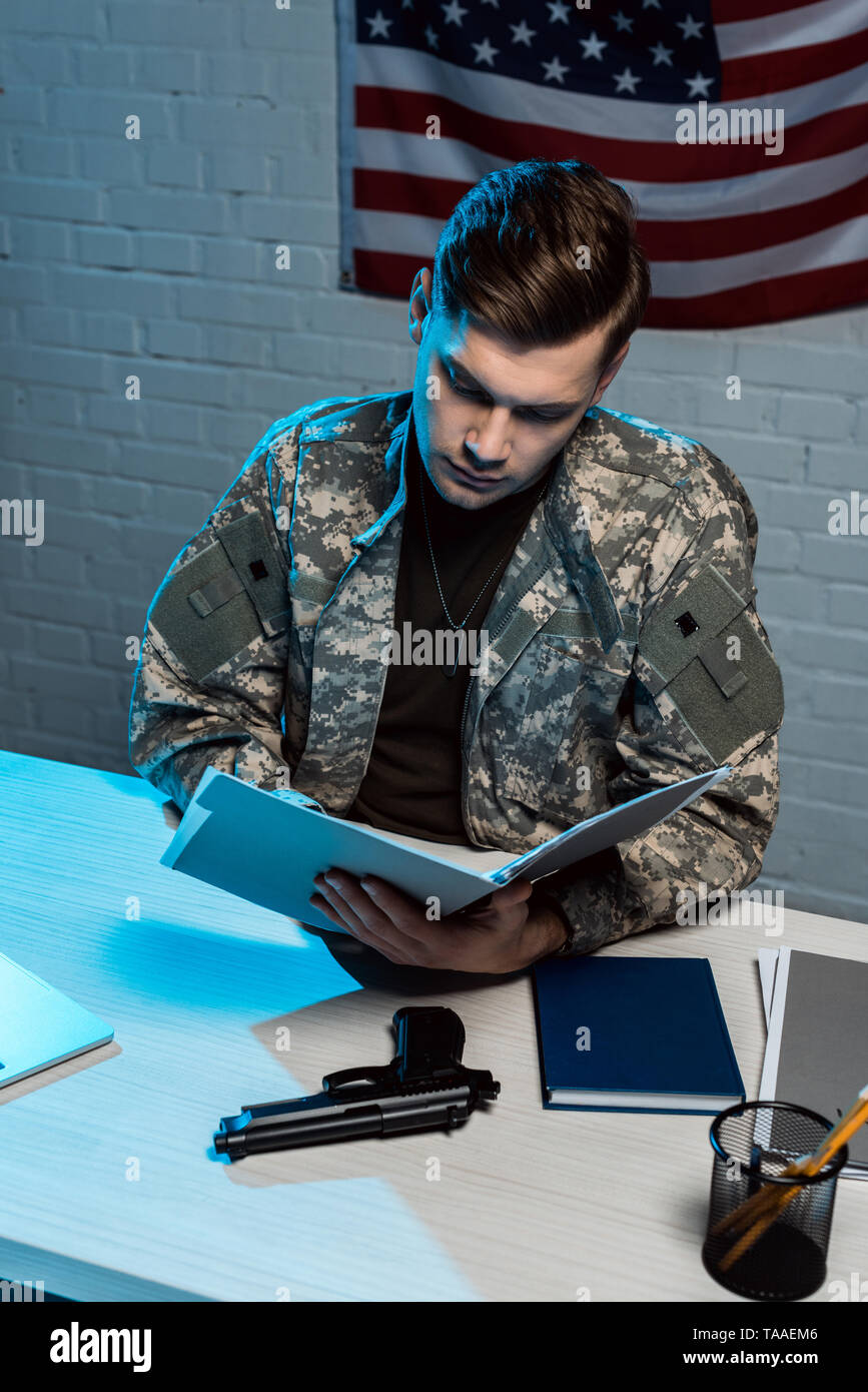 handsome soldier holding folder while sitting in modern office Stock ...