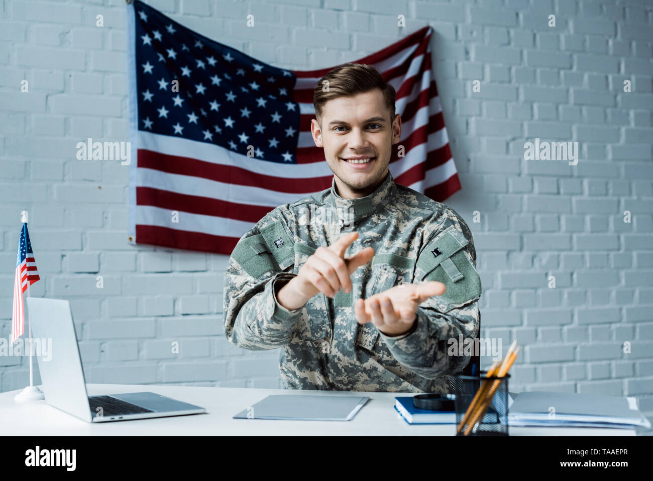 happy man in military uniform pointing with finger near laptop Stock ...