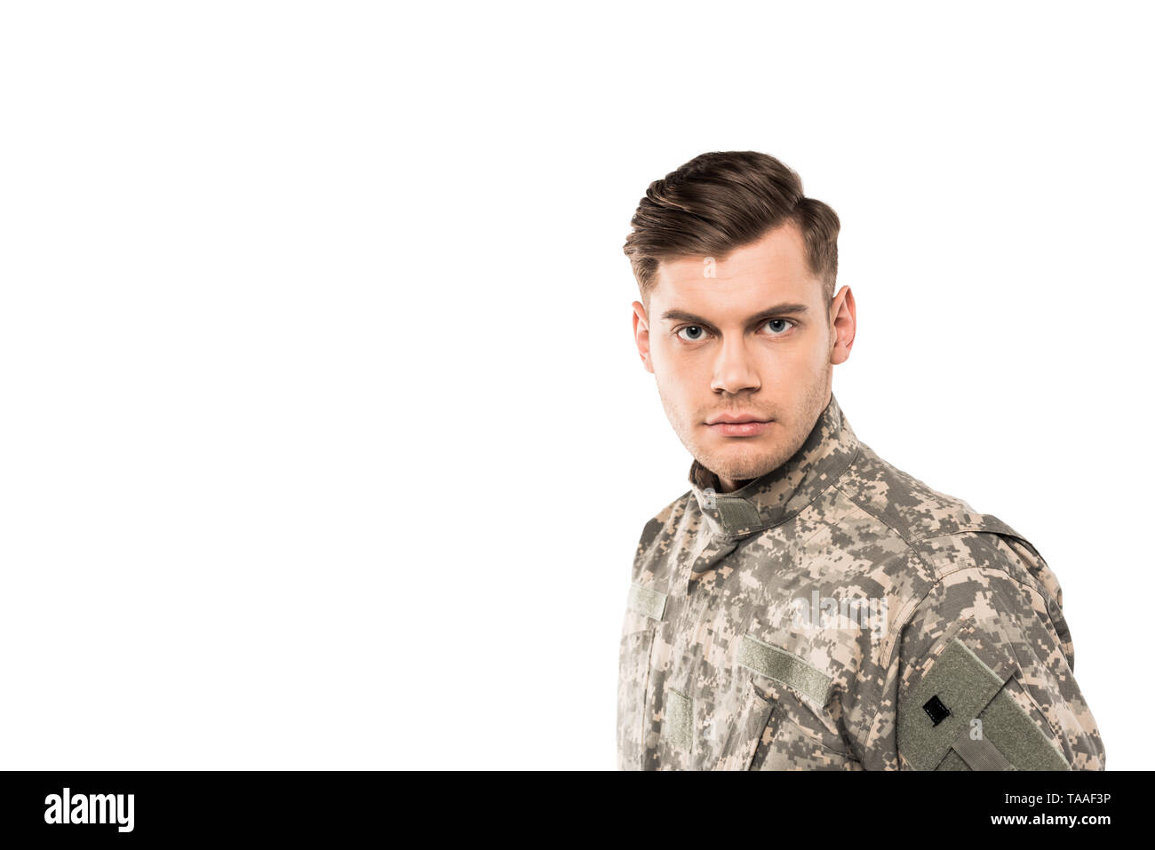 serious and handsome soldier in uniform looking at camera isolated on ...