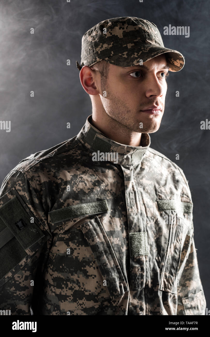 serious soldier in military uniform and cap on black with smoke Stock ...