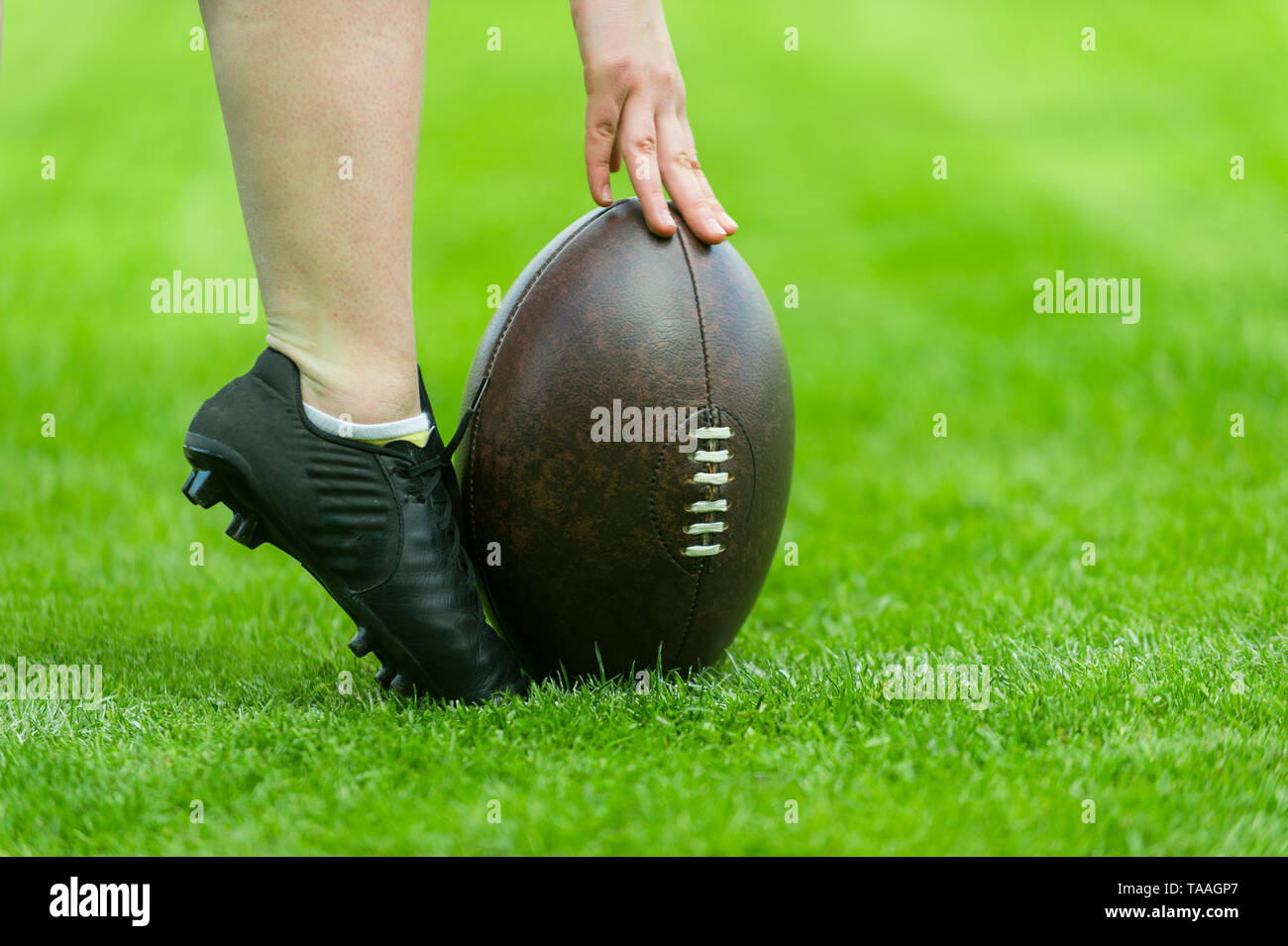 rugby ball with his feet on the grass field Stock Photo - Alamy