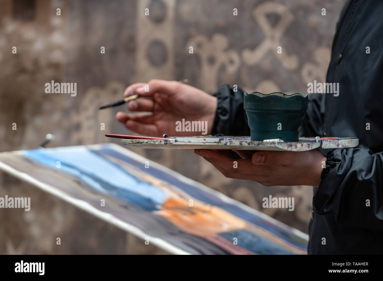 Artists hand with brush and palette painting street scene Stock Photo ...