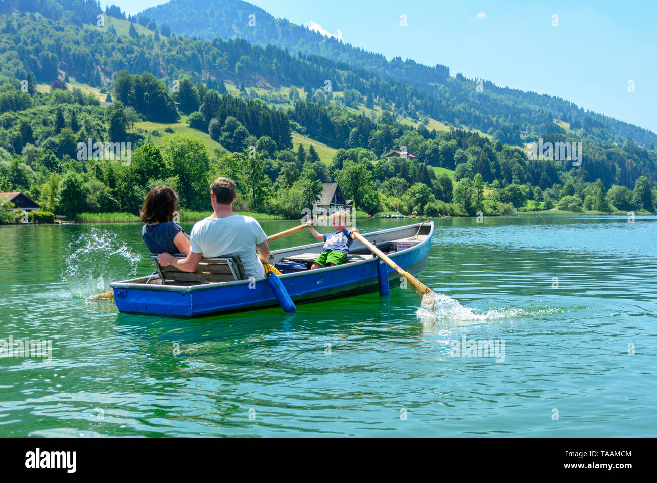 Family tour with rowboat on Alpsee Stock Photo - Alamy