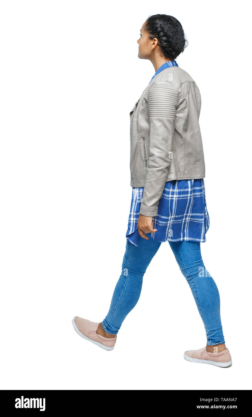 back view of a young black girl walking in jeans and a checkered shirt ...
