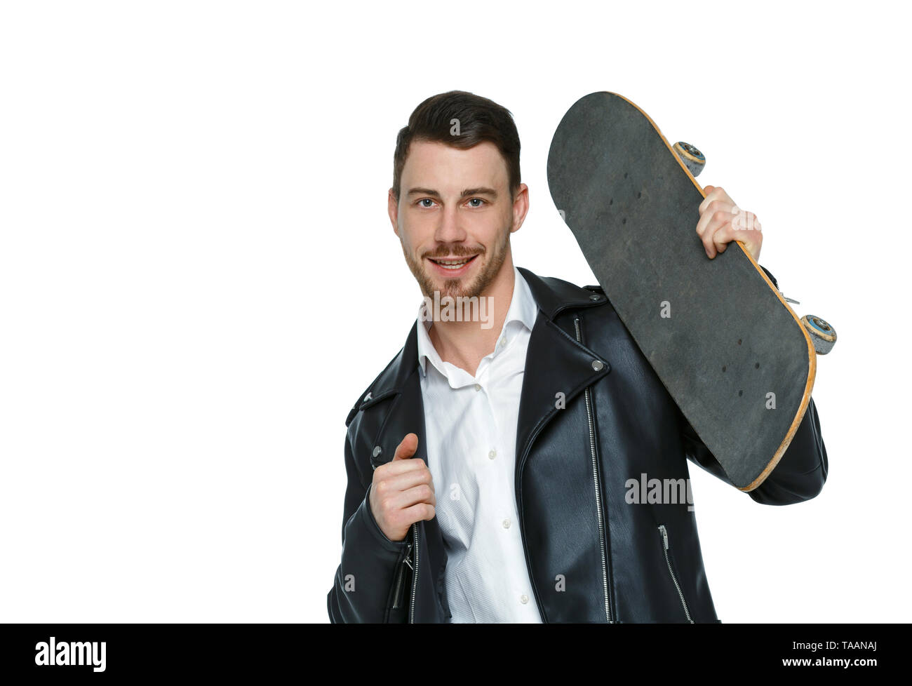 A man with a skateboard. A guy in stylish clothes and trousers posing ...
