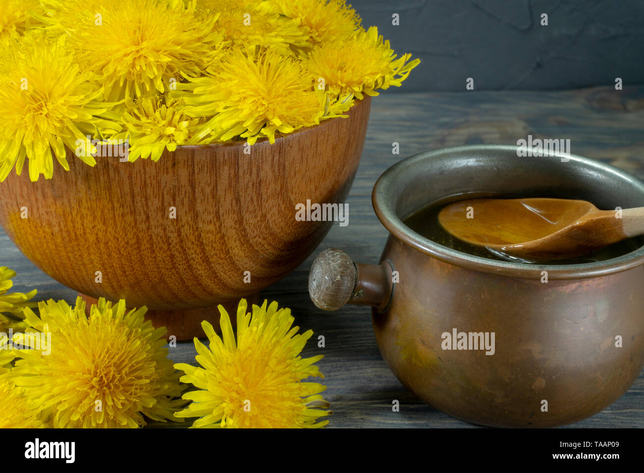 Pot of honey dripping off a spoon with colorful yellow spring ...